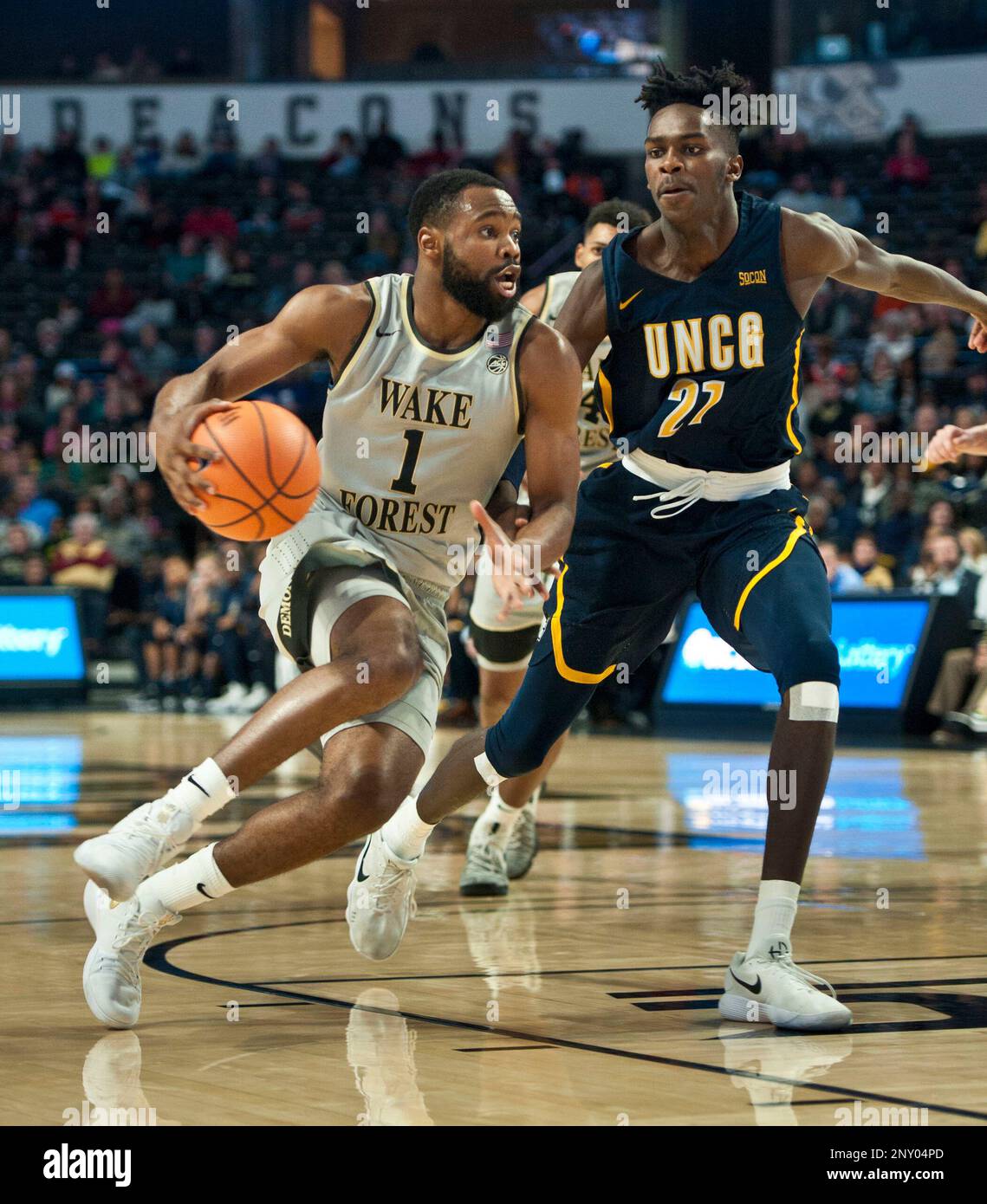 Wake Forest's Keyshawn Woods, left, drives the lane for a basket past ...