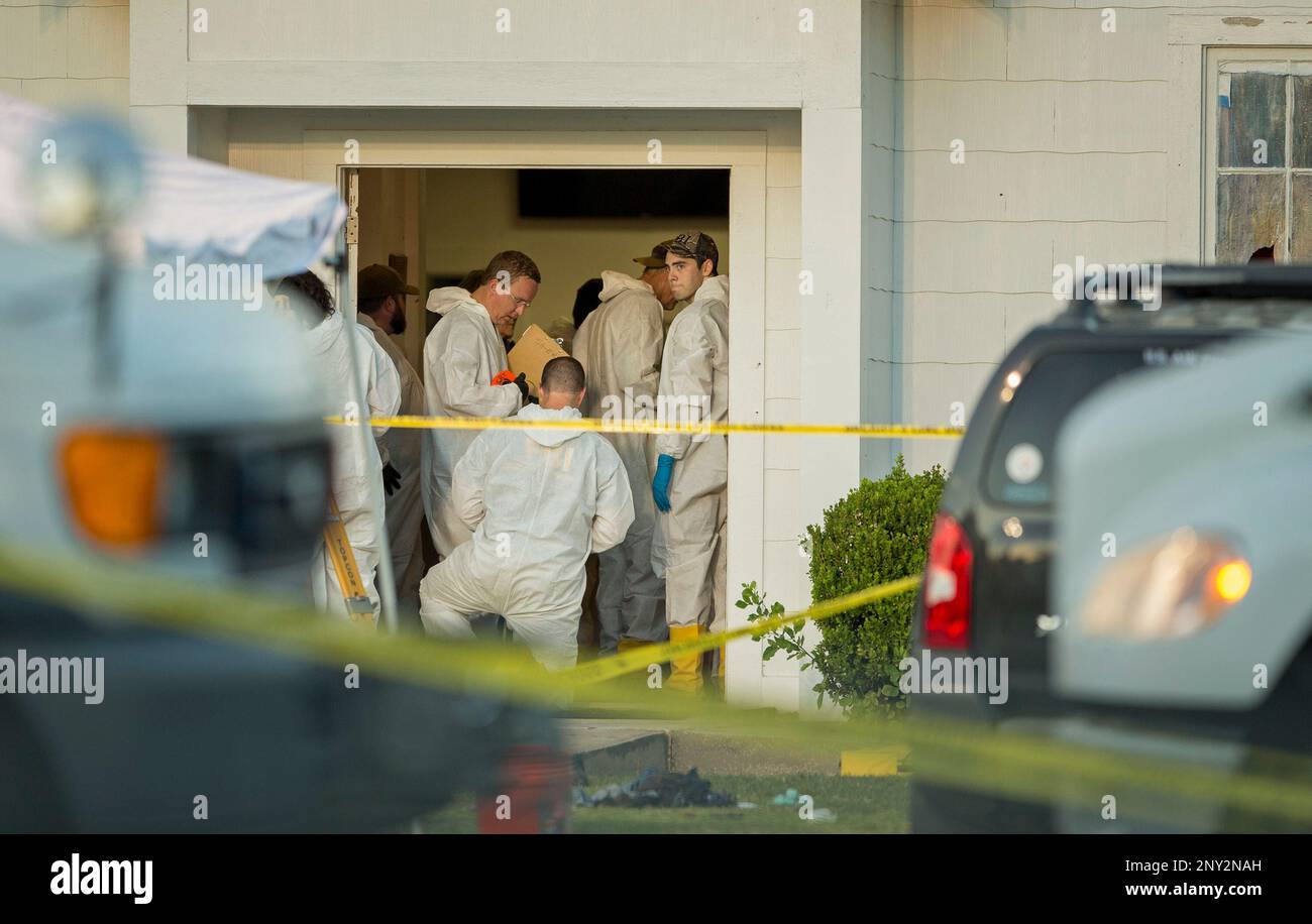 Investigators work at the scene of a deadly shooting at the First ...