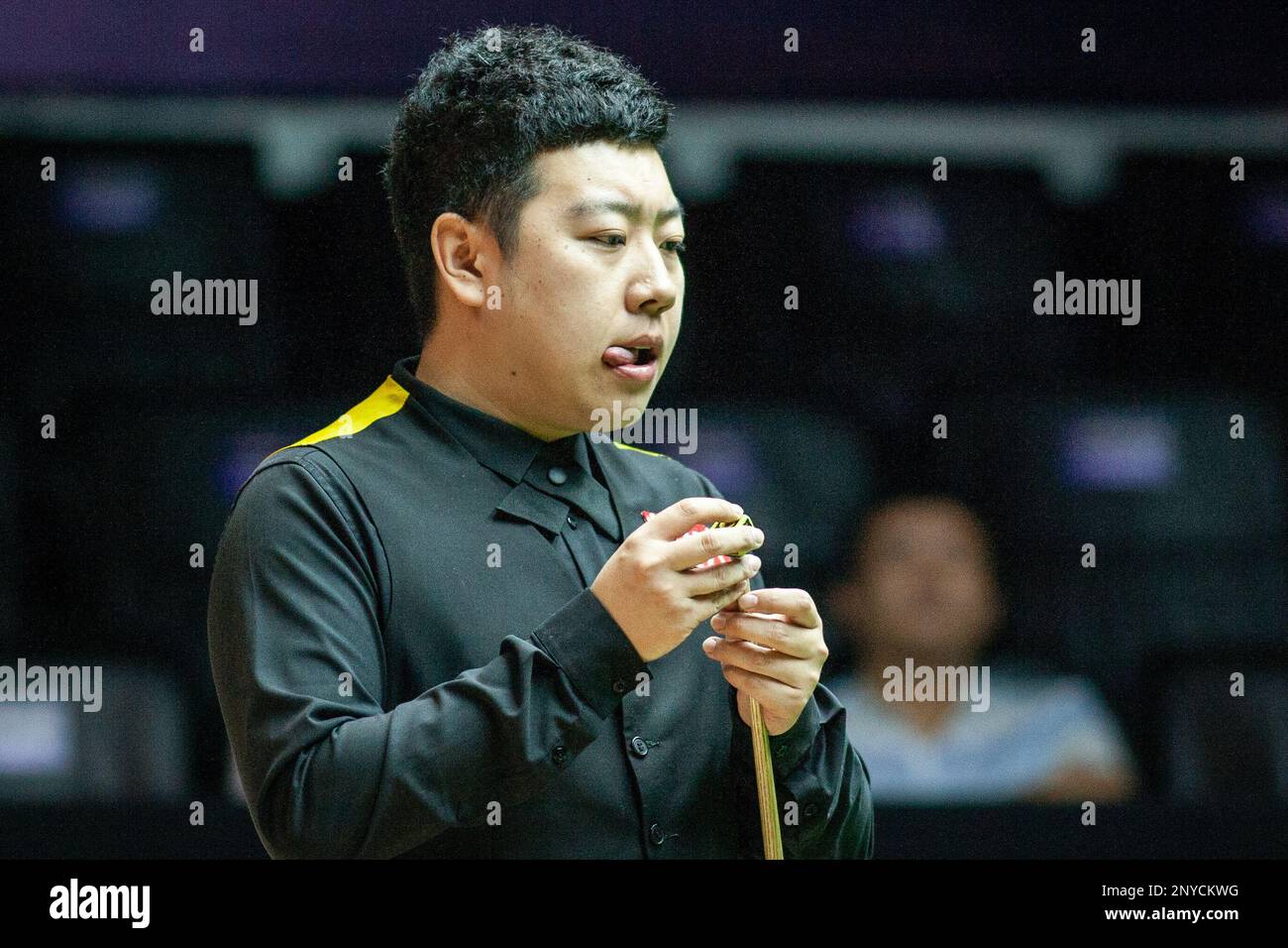 Li Hang of China chalks his cue as he considers a shot to Luca Brecel ...