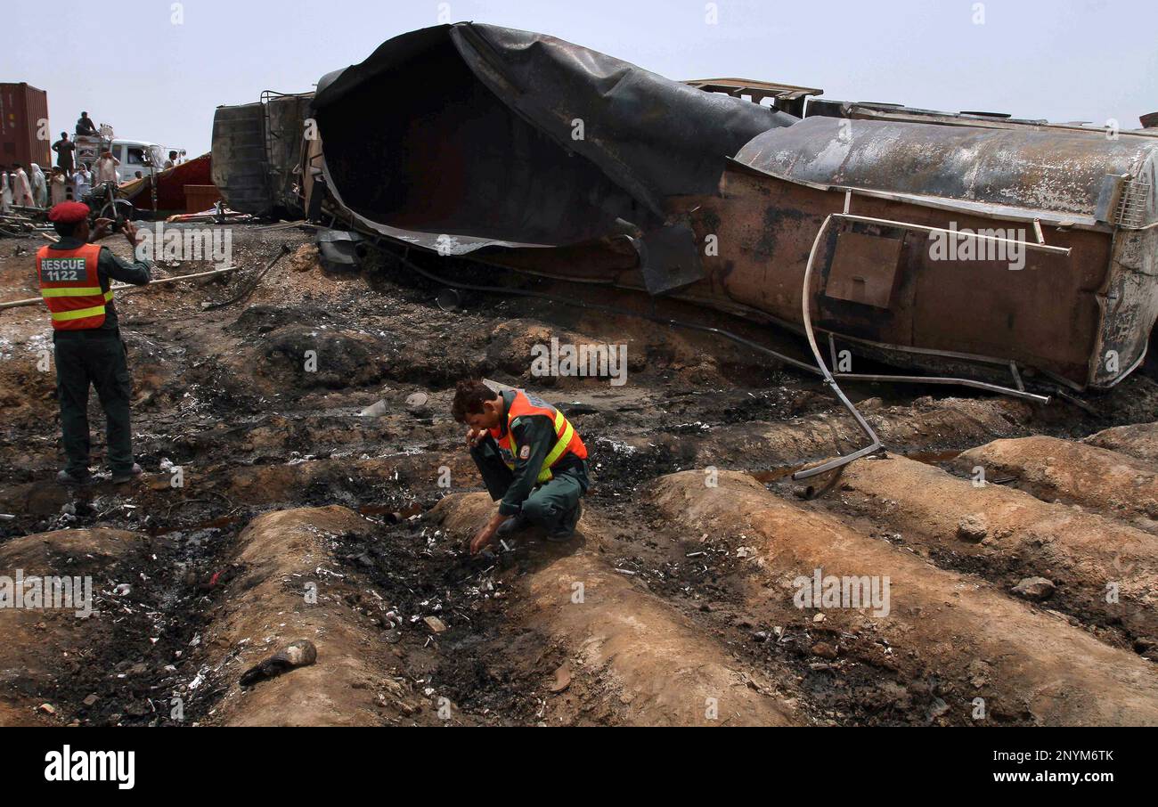 Pakistani rescue workers examine the site of an oil tanker explosion at ...