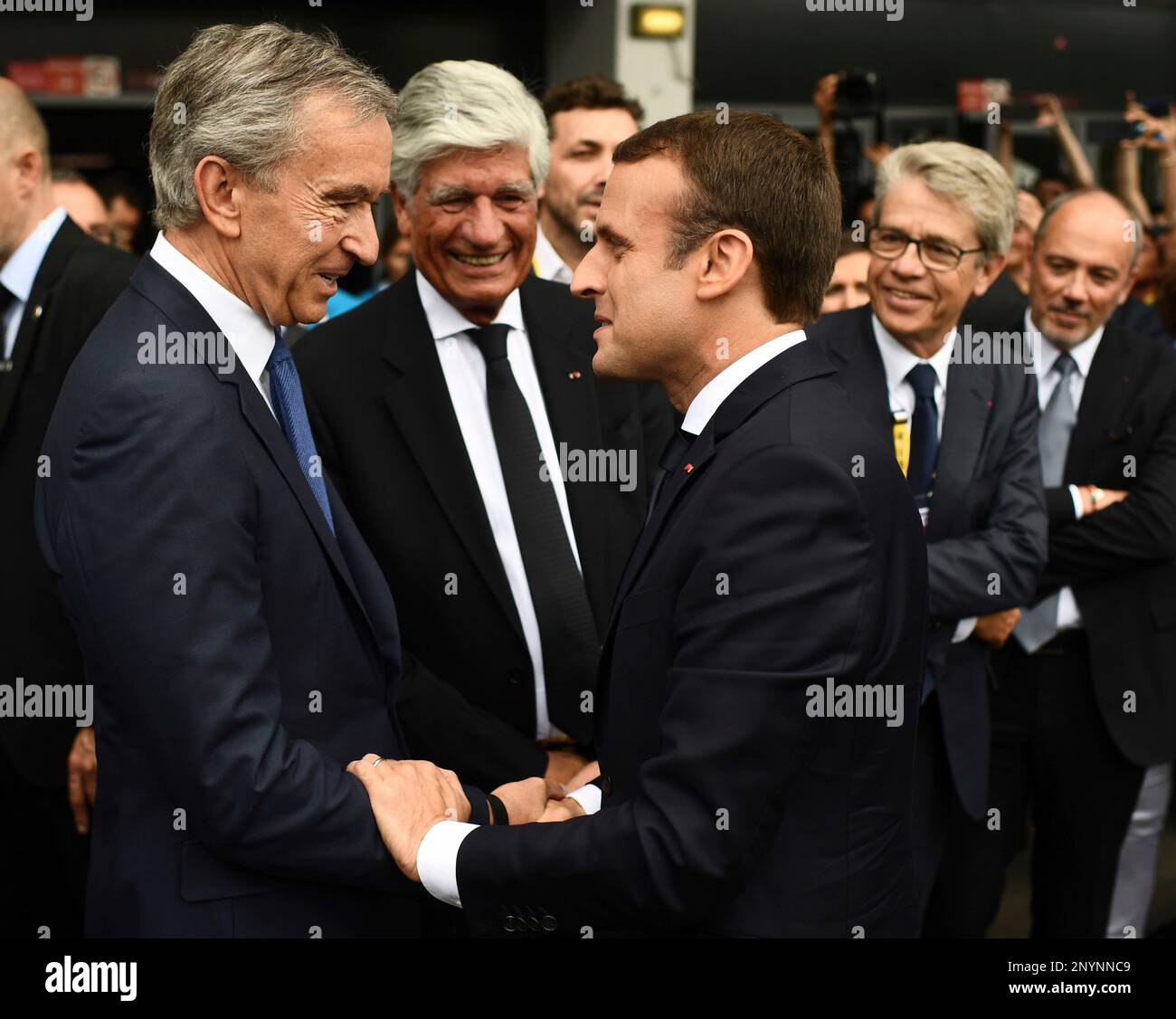 French President Emmanuel Macron, right, shakes hands with LVMH Group ...