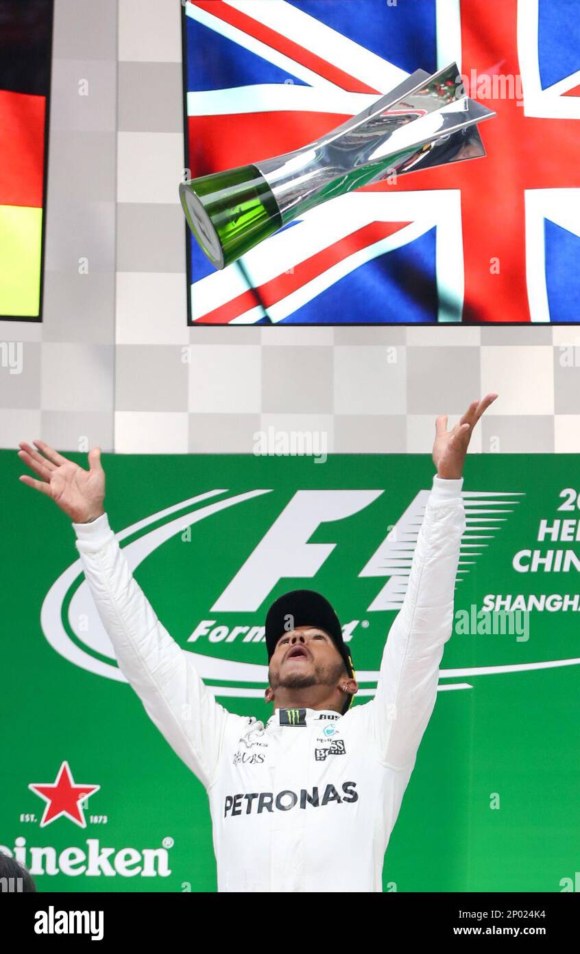 British F1 driver Lewis Hamilton of Mercedes tosses his trophy into the ...