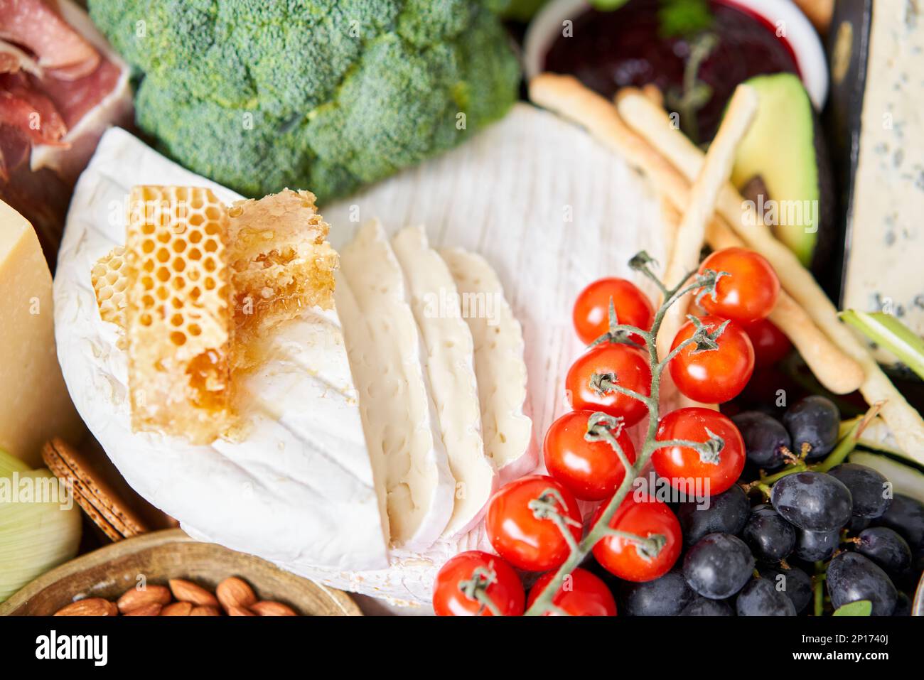 Brie Cheese mit Honig Nahaufnahme. Tisch voller mediterraner Vorspeisen ...