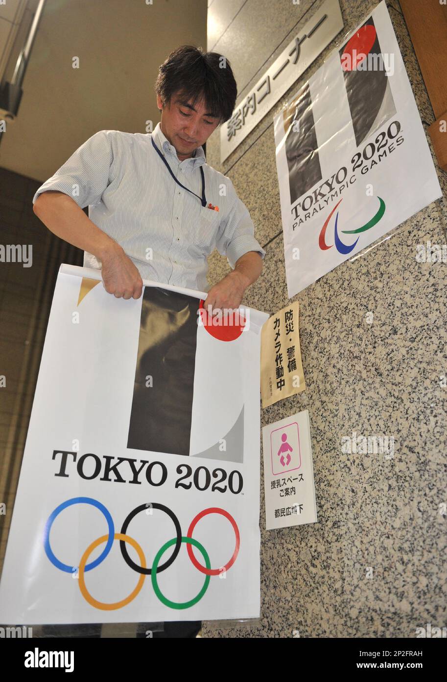 A person of Tokyo Government Office takeing off the controversial logos ...