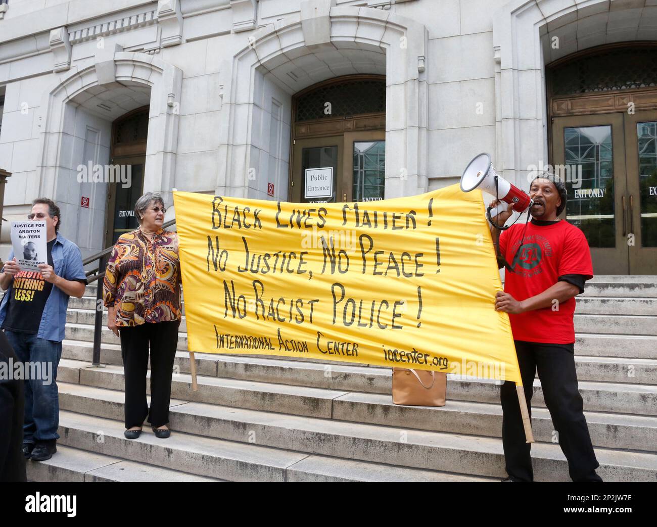 Protesters hold up signs on the Fulton County courthouse steps after a ...