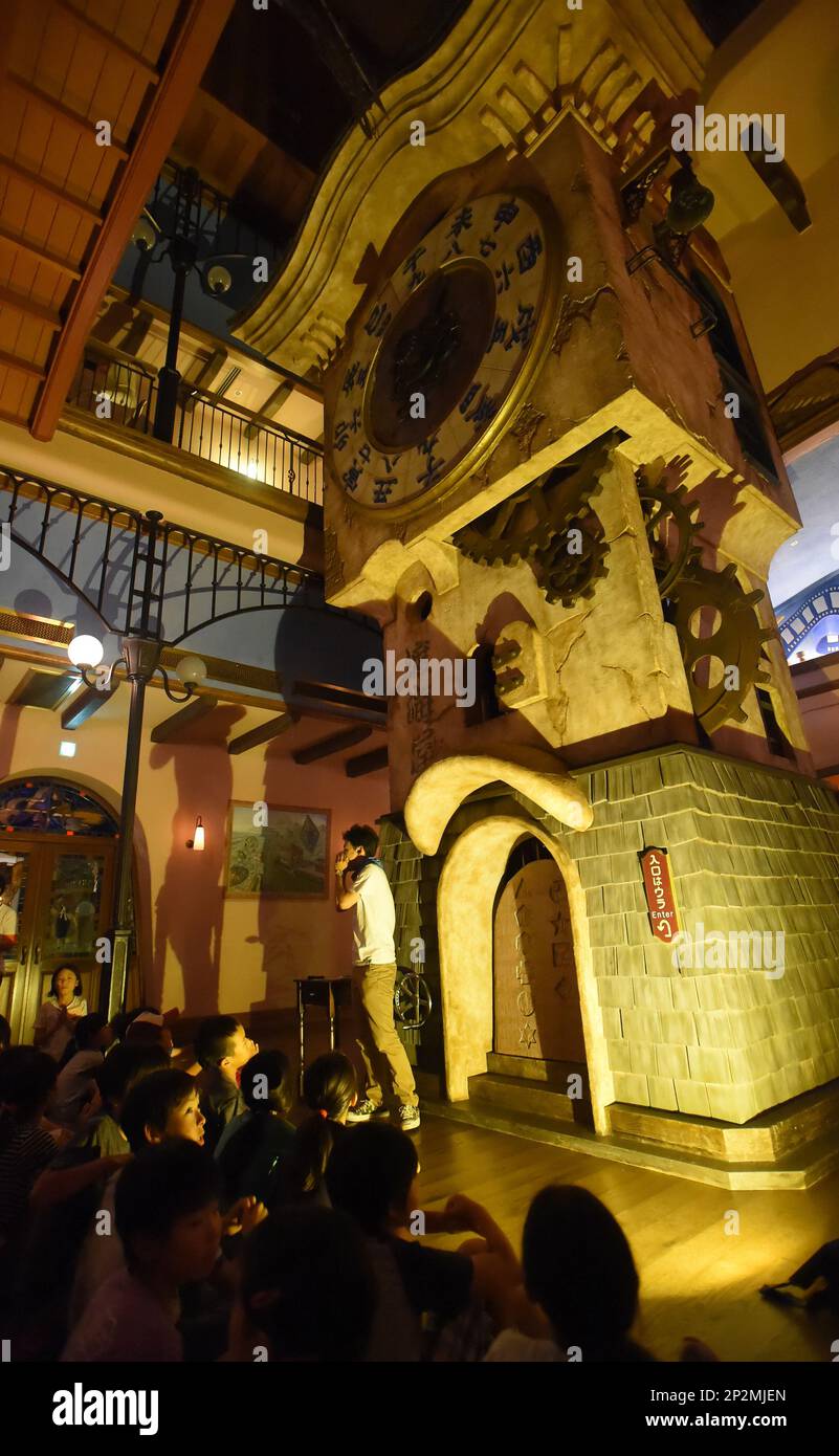 Students look up at a clock tower at the Ghibli Museum in Mitaka ...