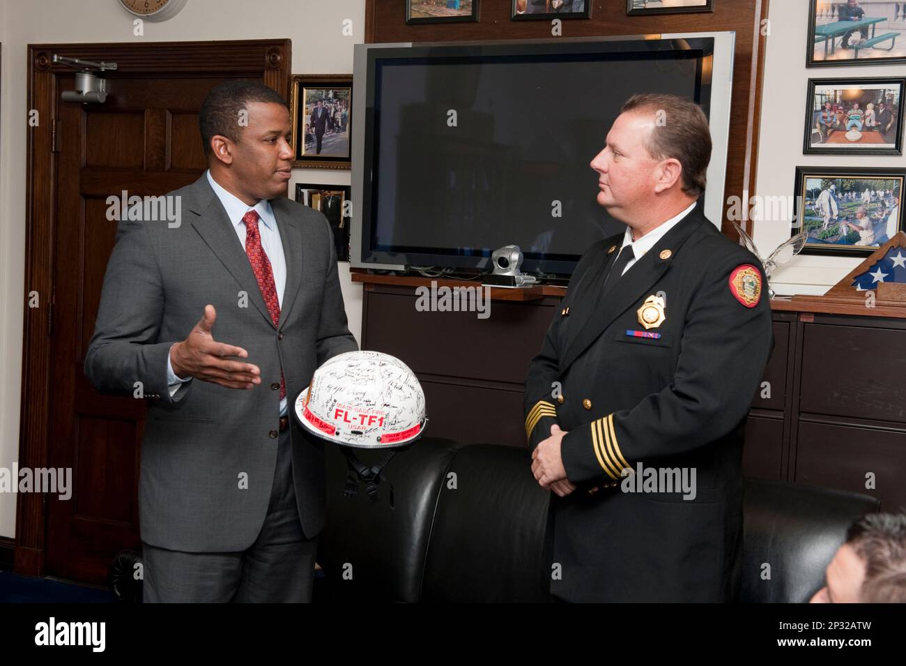 U.S. Rep. Kendrick Meek receives a signed fire fighter helmet from ...