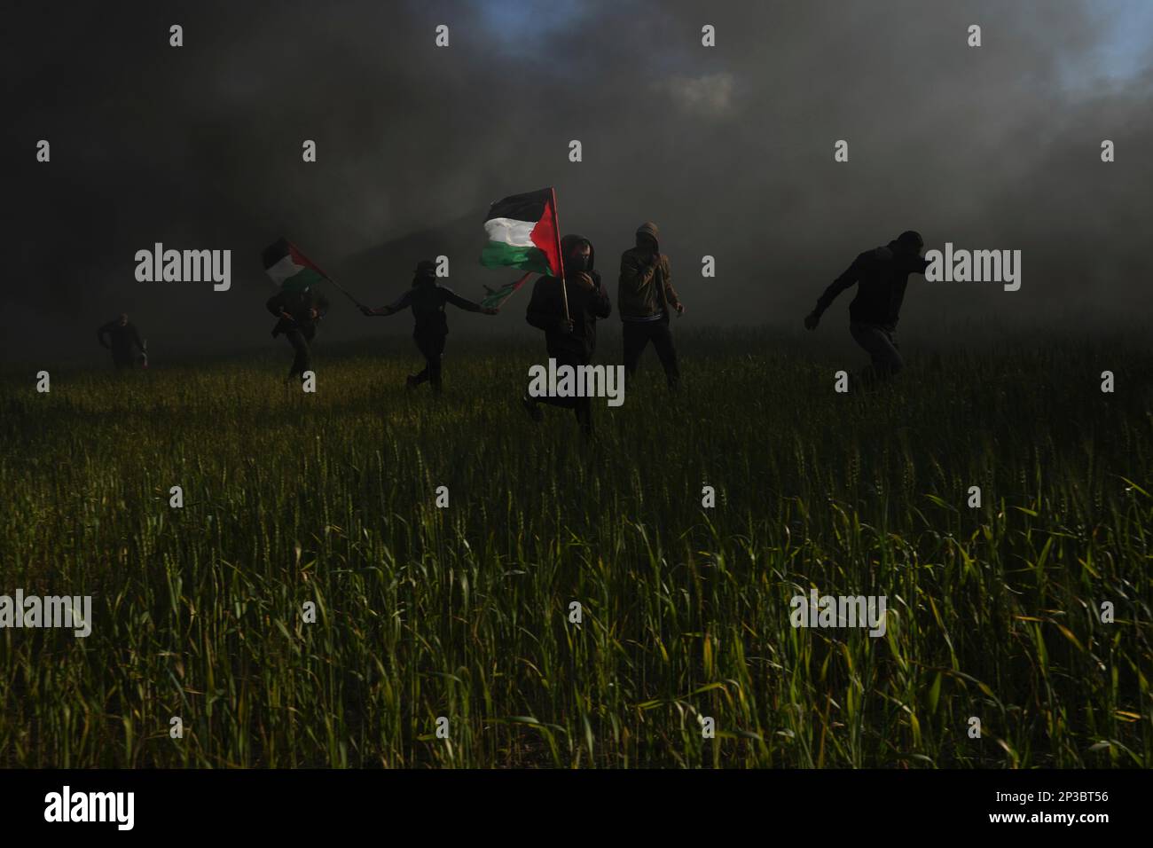 Palestinians carry national flags during a protest against Israeli ...