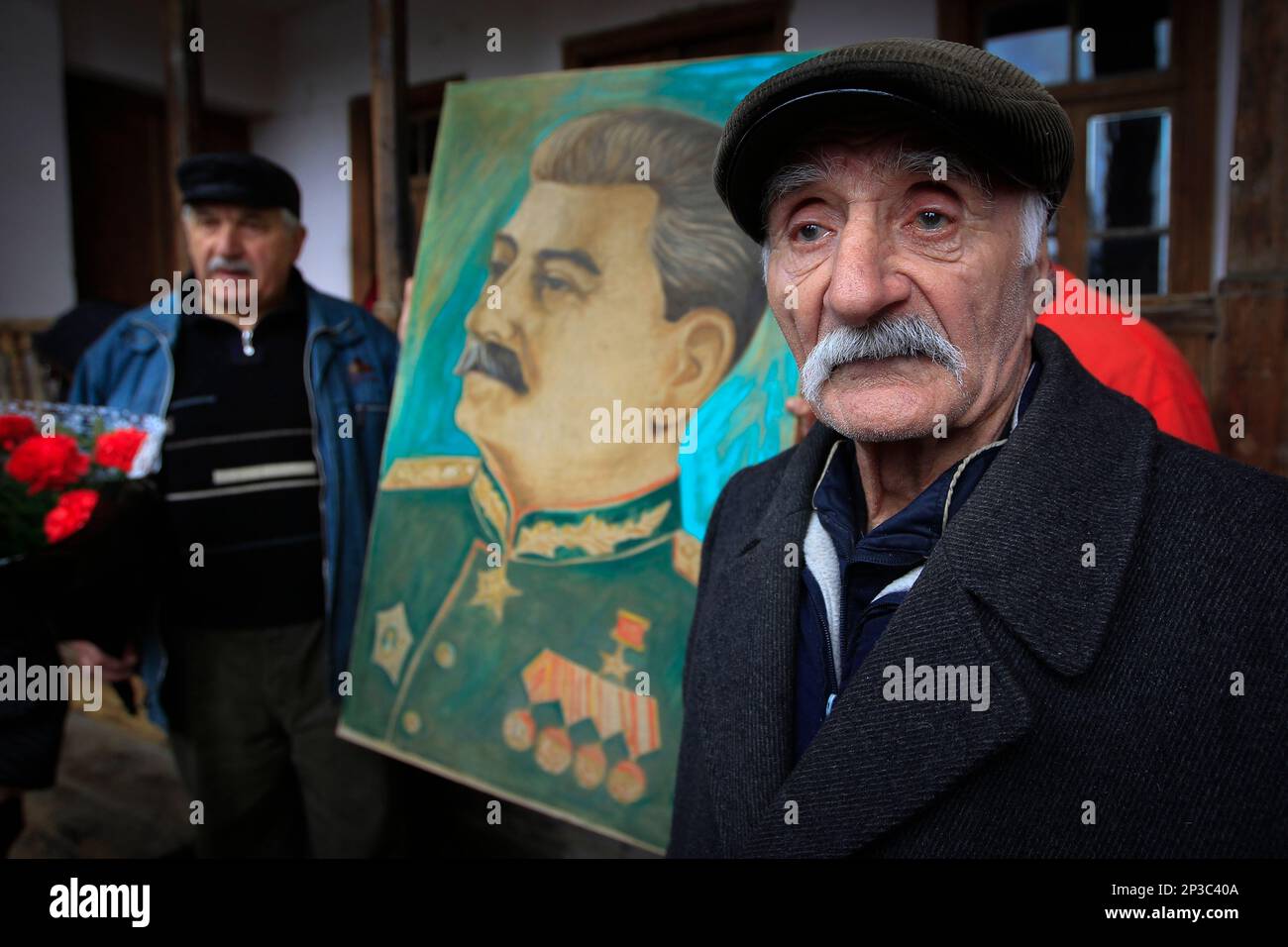 Georgians hold a portrait of former Soviet dictator Joseph Stalin ...