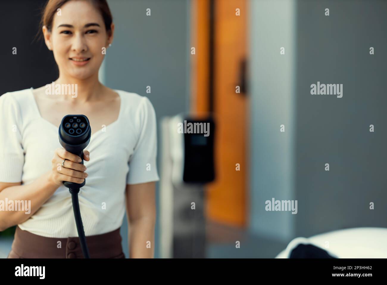 Nahaufnahme-Mann hält und zeigt einen EV-Stecker für Elektrofahrzeug ...