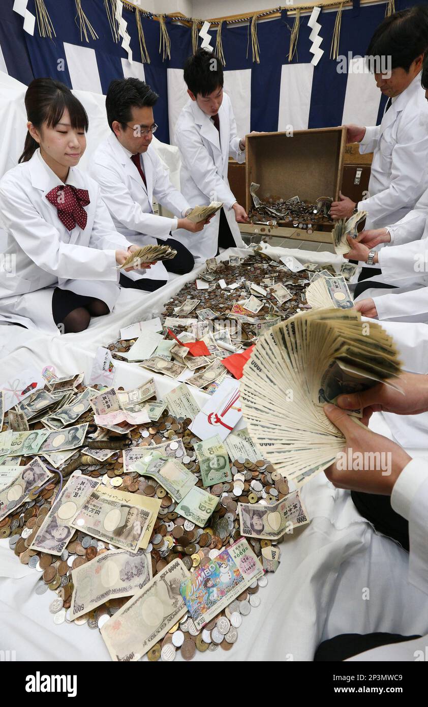 Bank employees, clad in a white robe, start to calucuate money offering ...