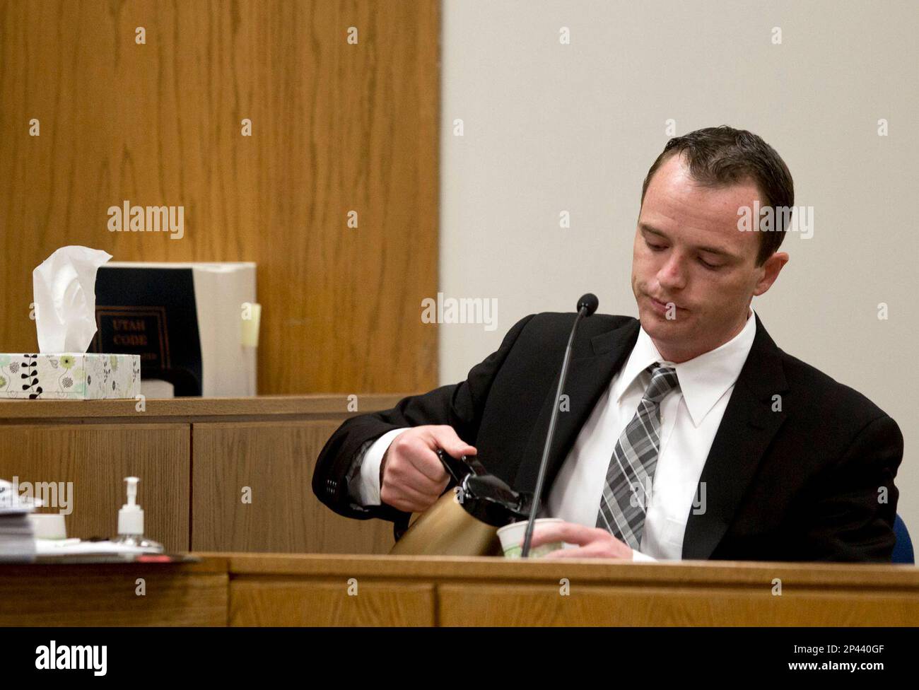 Defendant Conrad Truman pours a cup of water while he is cross-examined ...