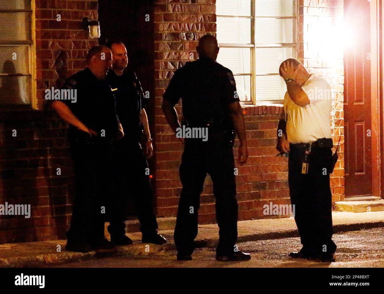Police wait outside an apartment early Tuesday, Aug. 26, 2014, in Tulsa ...