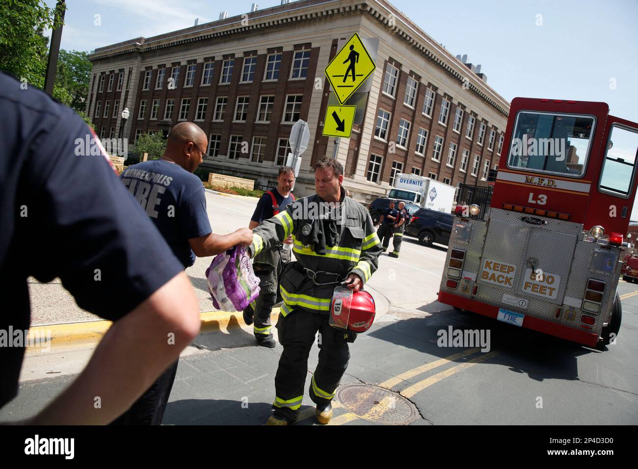 Firefighters stand outside a building at the University of Minnesota ...