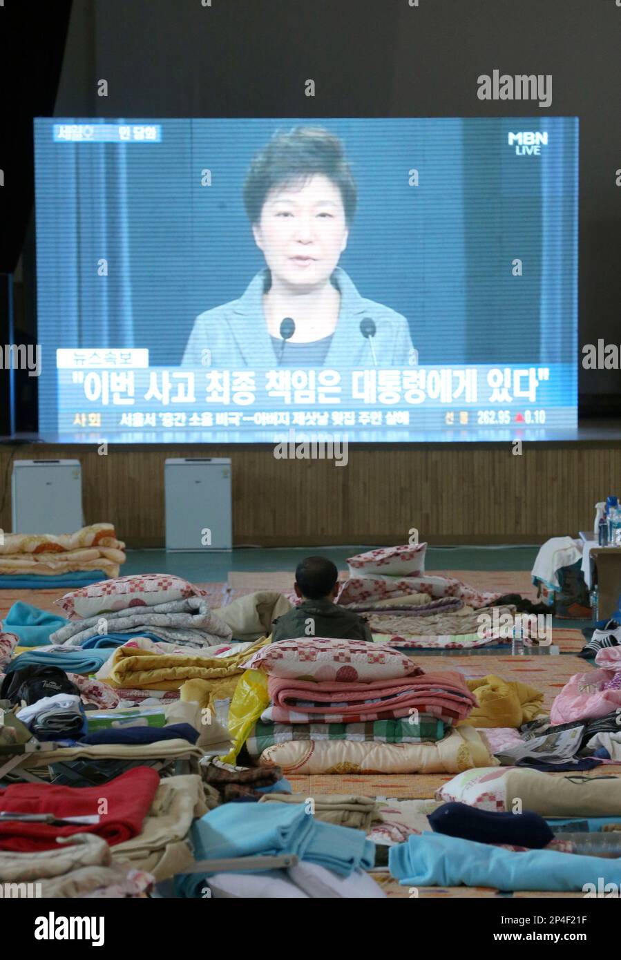 A relatives of victim of the sunken ferry Sewol watches a televised address by South Korean ...