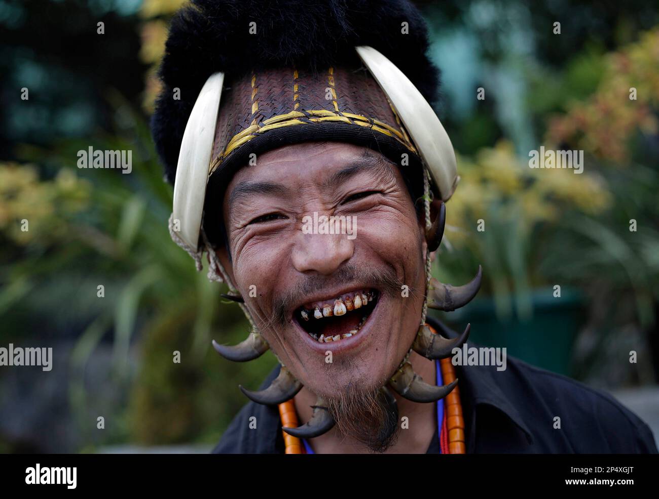 A Naga dancer in traditional attire smiles at the camera during the ...