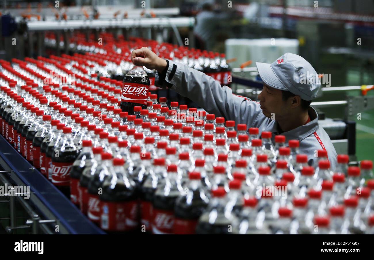An employee works on a production line at the Coca-Cola company's new ...