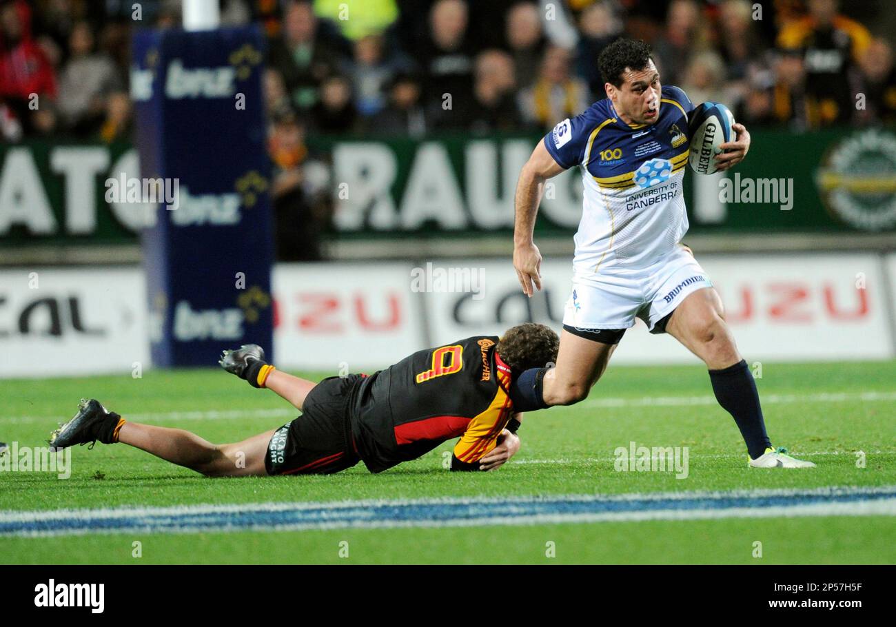 Brumbies' George Smith, right, slips the tackle of Chiefs' Tawera Kerr ...