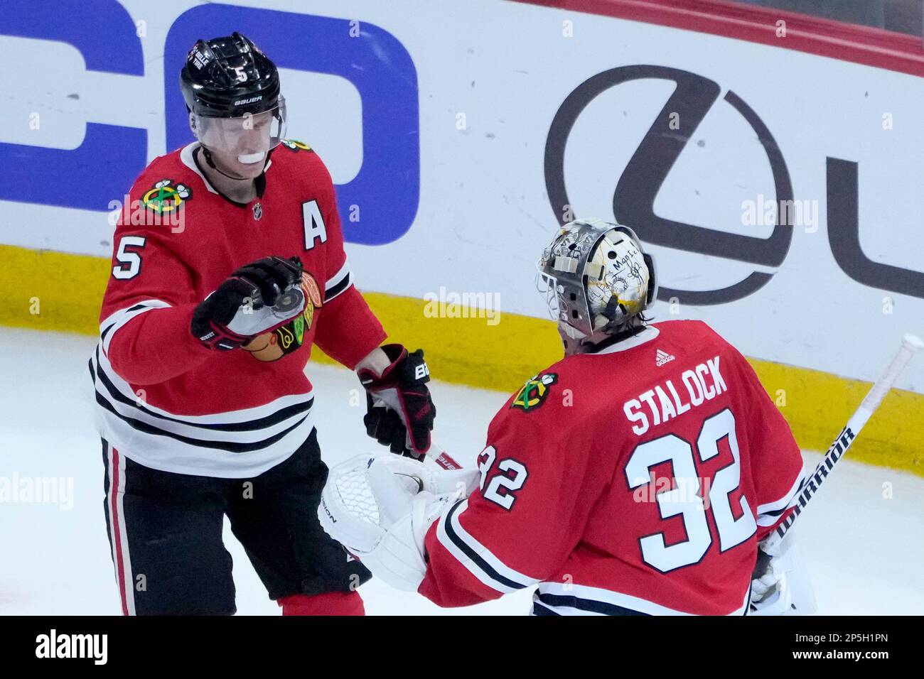 Chicago Blackhawks' Connor Murphy (5) presents goalie Alex Stalock with ...