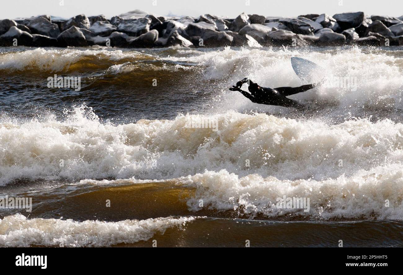 Mike Sabatino of Grand Haven, Mich. falls into the water while surfing ...