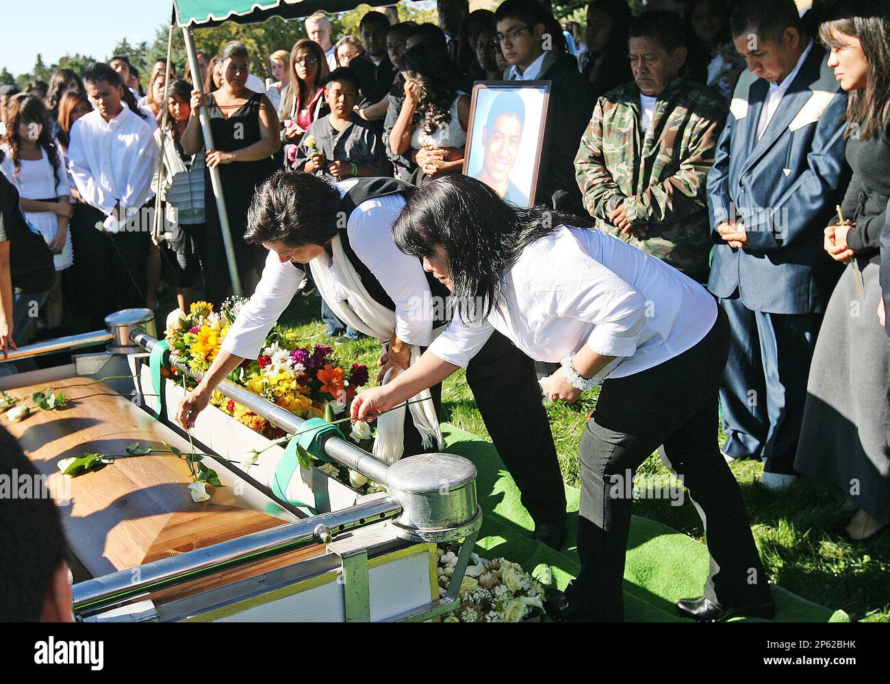 Family and friends of Edwin Cardoso place roses on his casket during ...