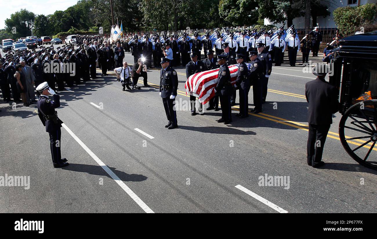 Police officers carry the casket to a horse-drawn caisson before the ...