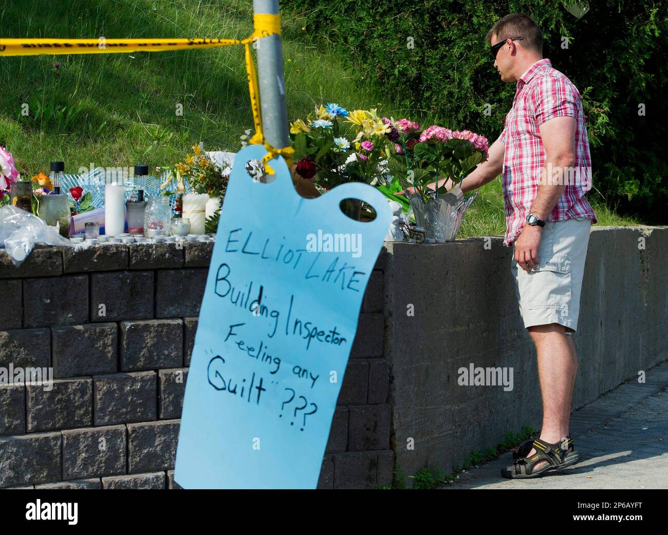 A man lays flowers at a memorial site the day after the recovery of two ...
