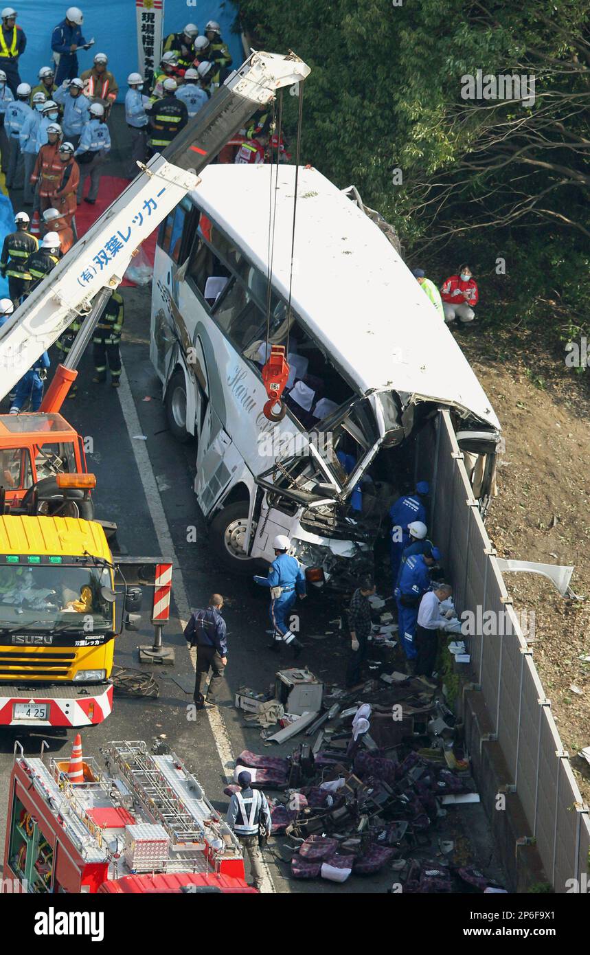 Rescuers work near the wreckage of a destroyed bus on a highway in ...