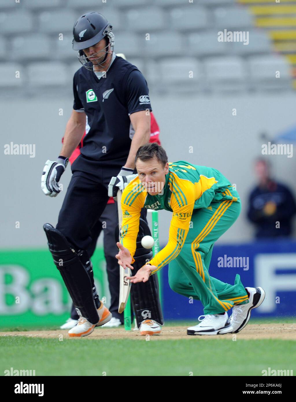 South Africa's Johan Botha fields off his own bowling in front of New ...