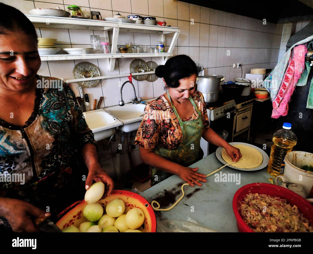 Eine usbekische Frau rollt Teig in einem kleinen Laden in Bukhara, Usbekistan, um Samsa ...
