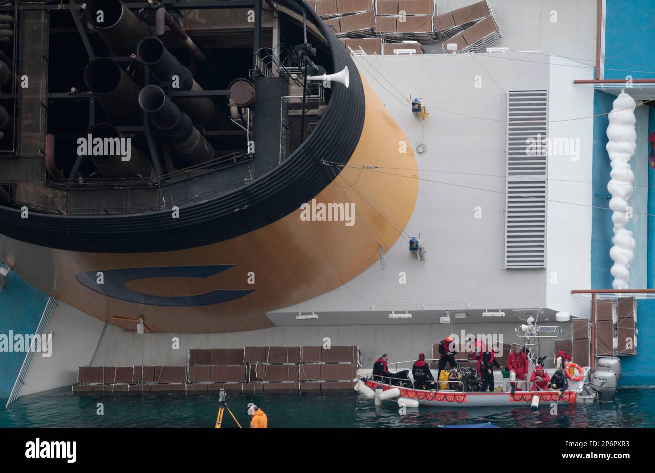 Rescuers work at the cruise ship Costa Concordia keeled over on its ...
