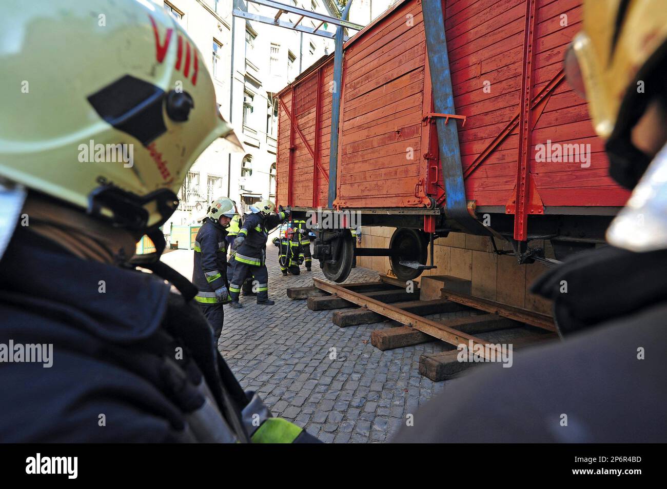 Firemen use a crane to lift a WWII cattle car to put it in its place ...