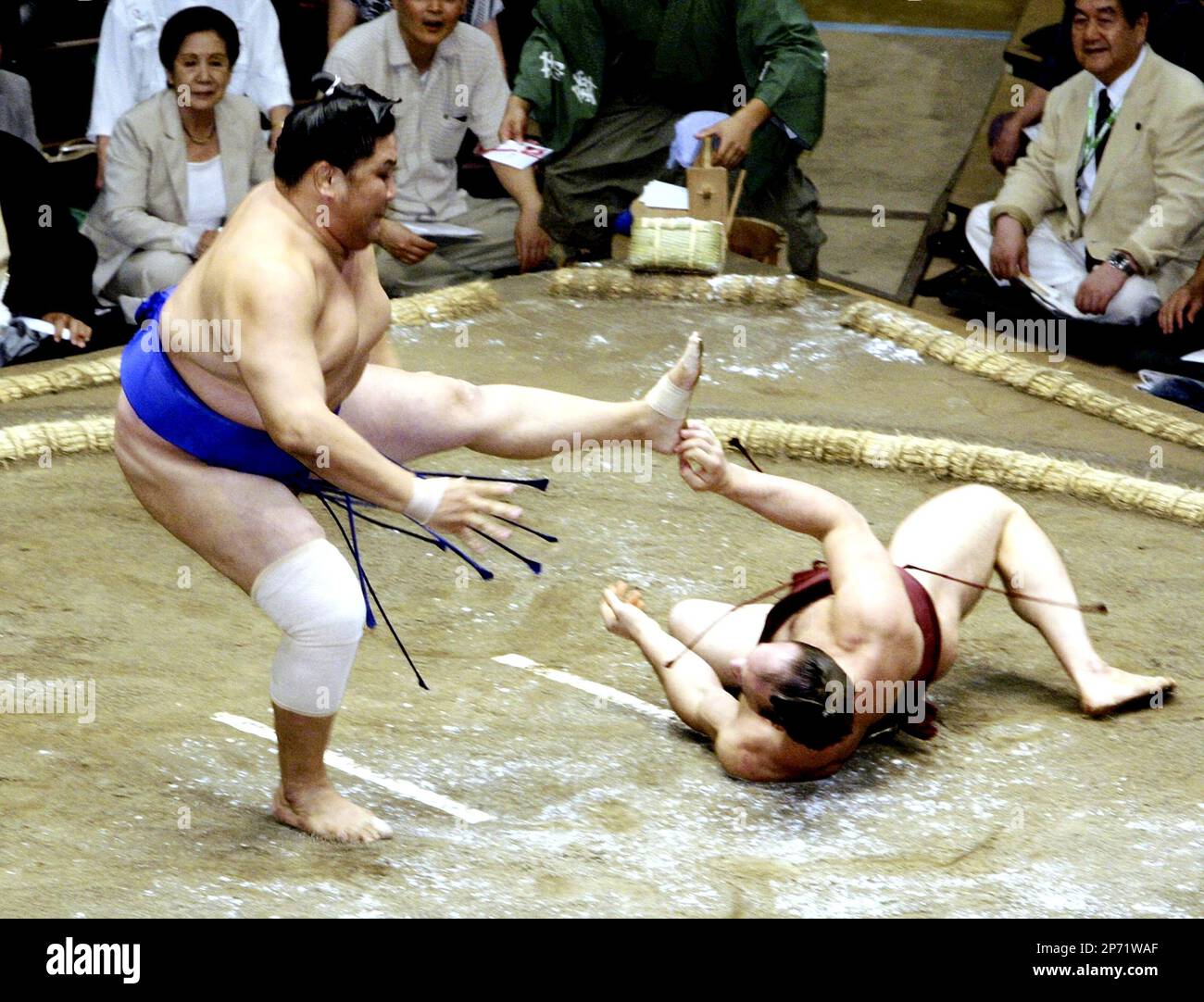 Czech maegashira No. 15 Takanoyama (R) is pulled down from back by Mongolian maegashira No. 12 ...