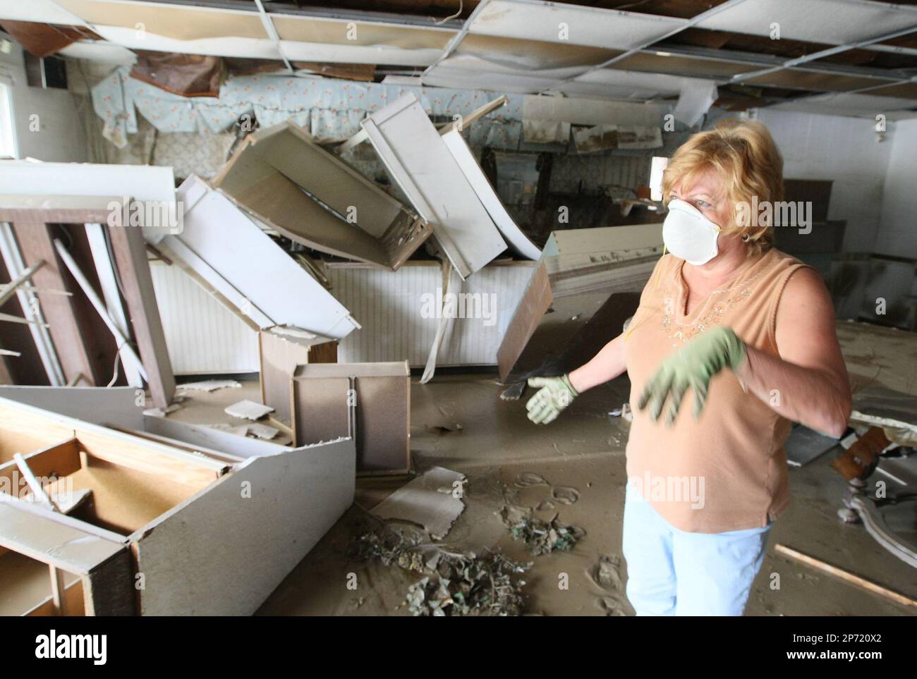 Mary Ann Stopay shows the damage flood waters caused inside her shop ...