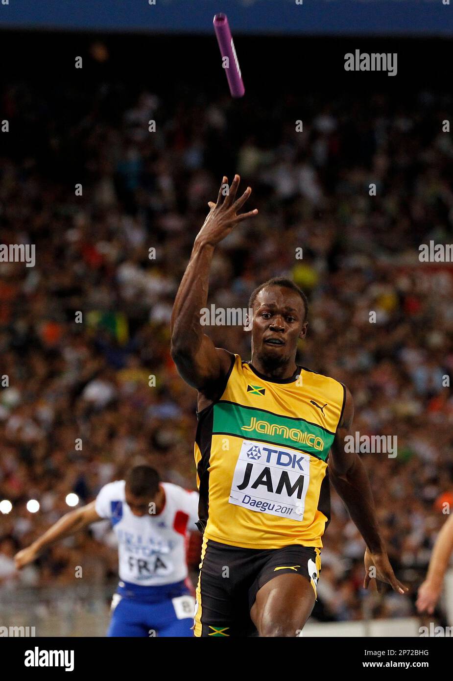 Jamaica's Usain Bolt throws the baton into the air as he crosses the finish line to win the Men ...