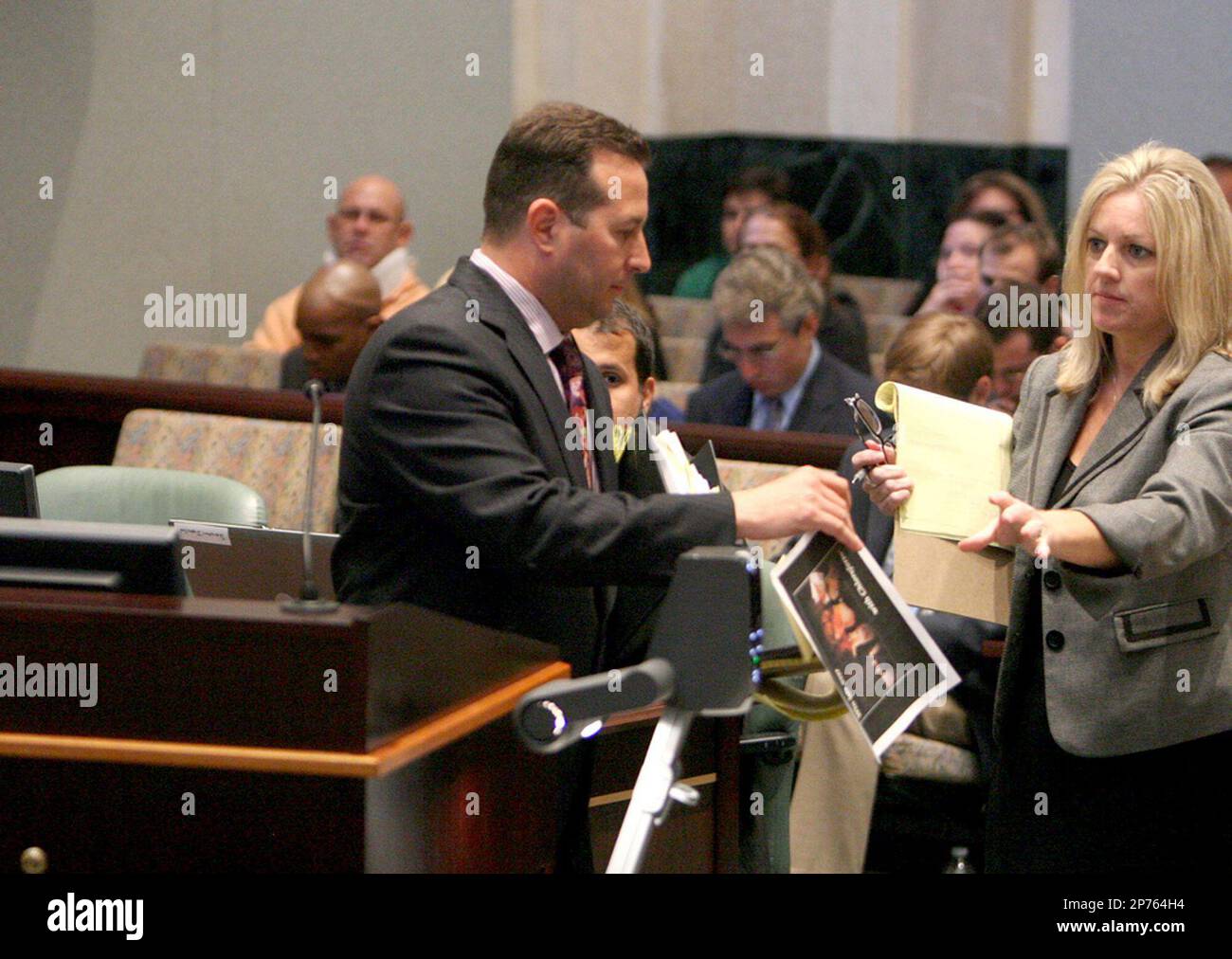 Defense attorney Jose Baez, left, hands an evidence photo to assistant ...