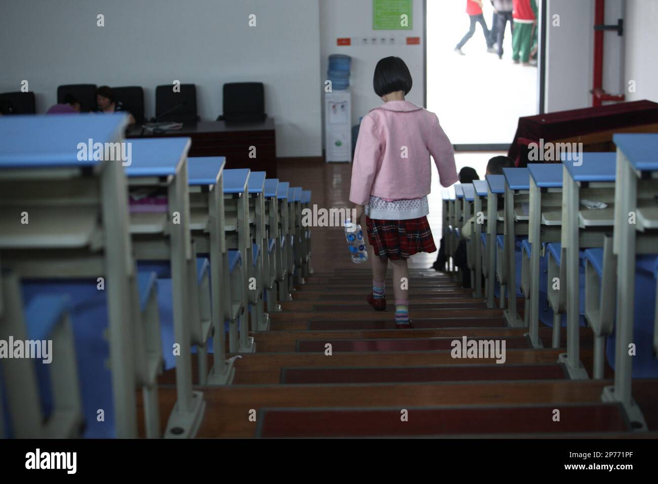 A student with artificial limb walks down stairs in a classroom at the ...