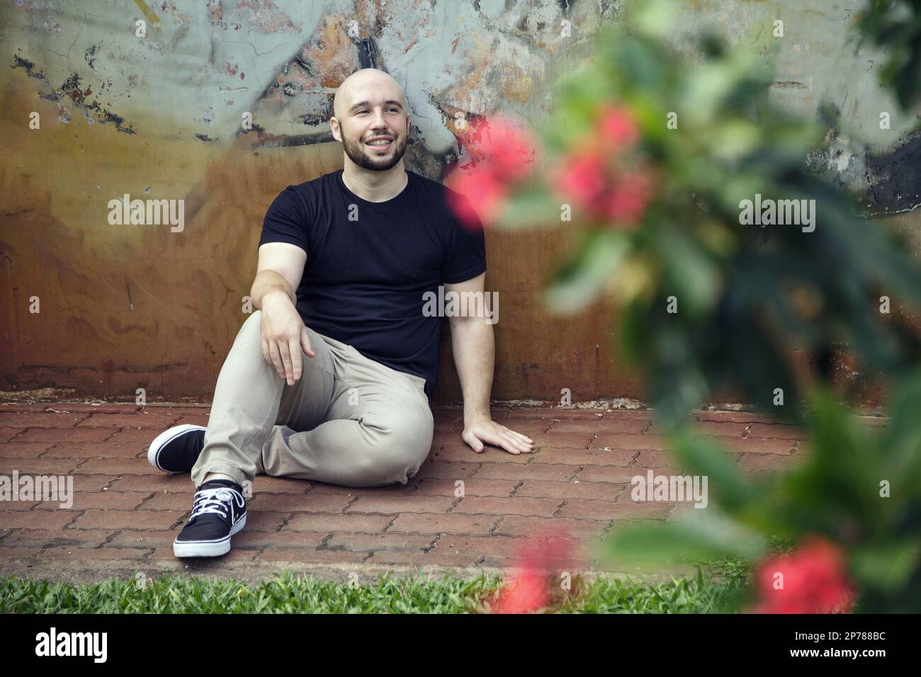 Ein junger, lächelnder, bärtiger Mann, der auf dem Bürgersteig in einem ...