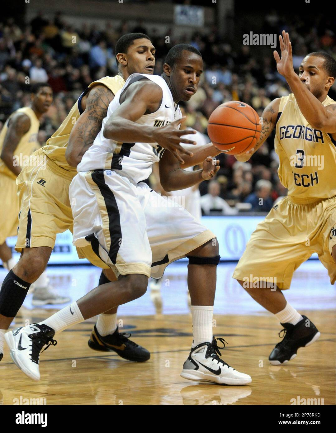 Wake Forest's Travis McKie, center, keeps the ball away from Georgia ...