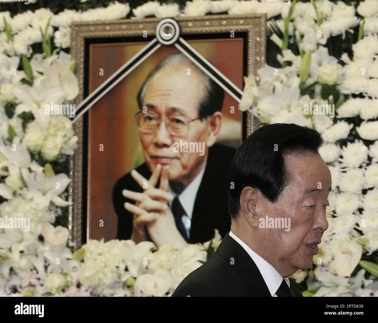 Former South Korean President Kim Young-sam walks by a portrait of ...