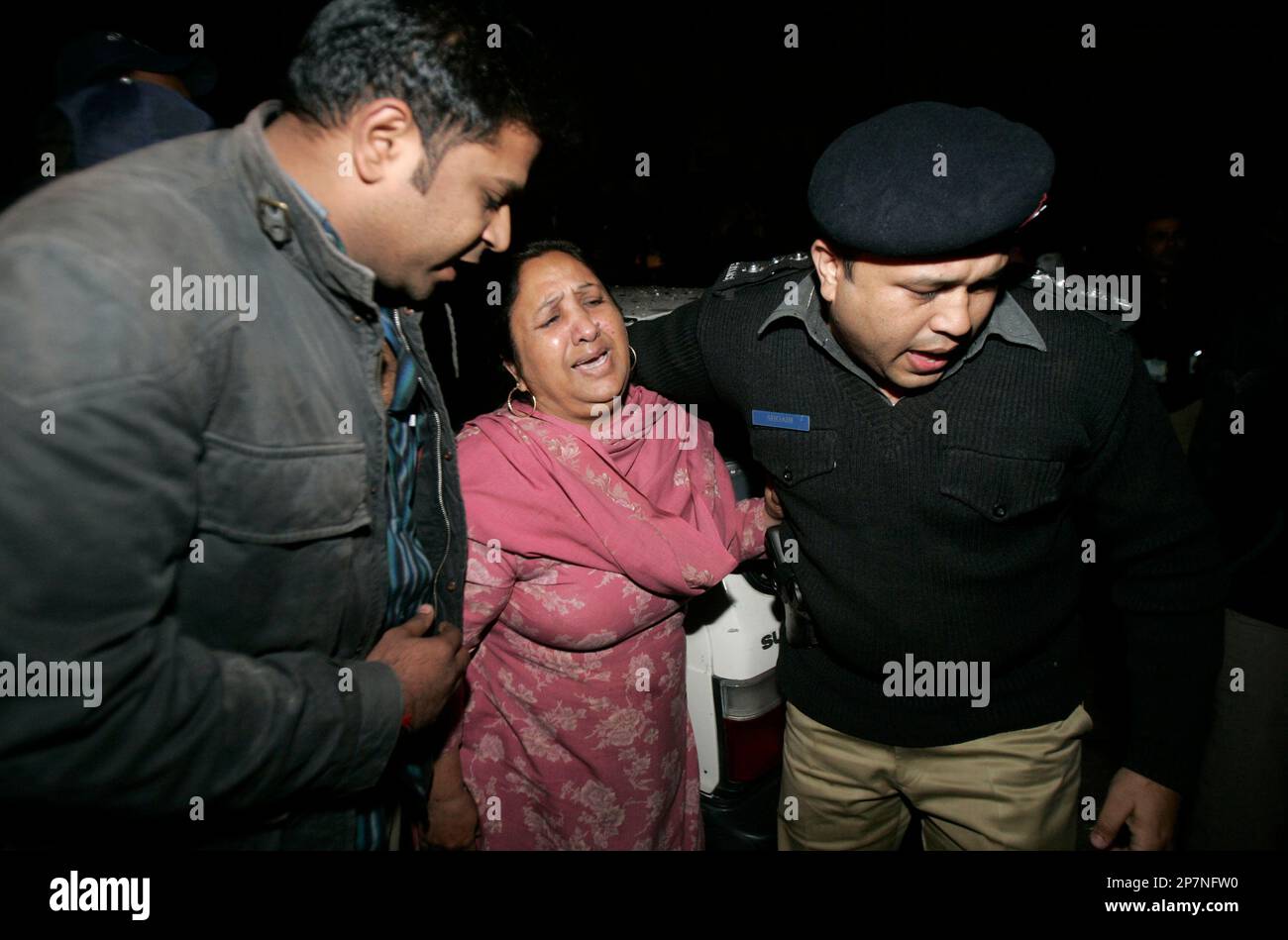 A Pakistani woman is comforted by a police officers, after a series of ...