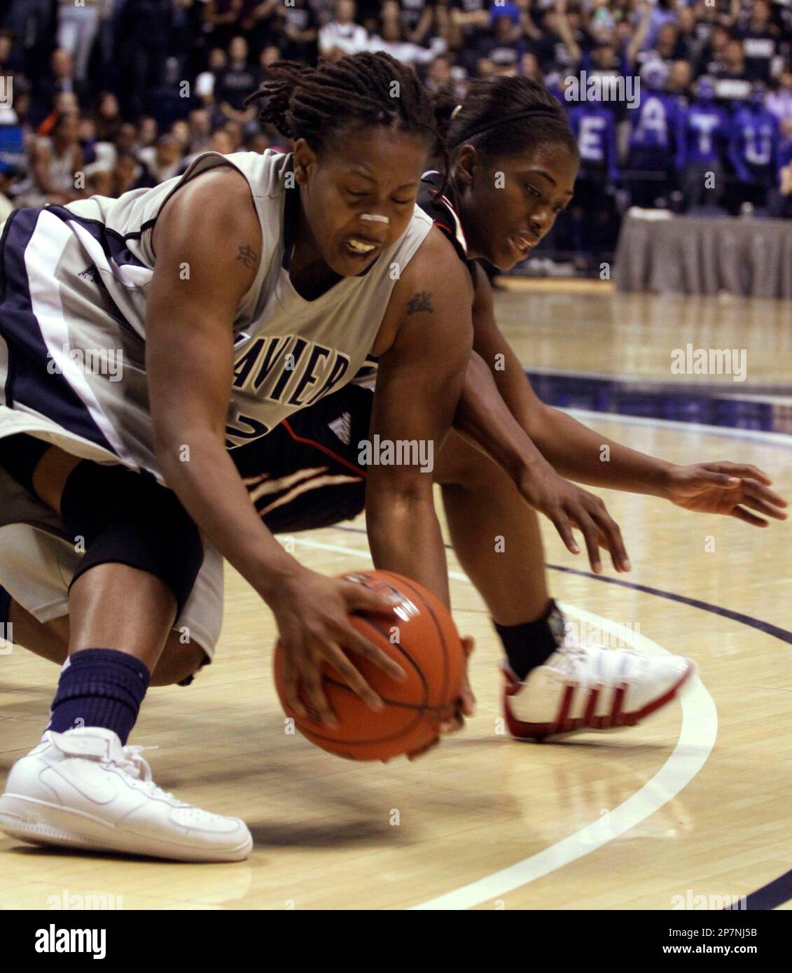 Xavier's April Phillips grabs a loose ball from Cincinnati's Carla ...
