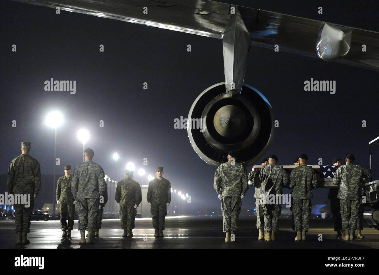 An Army carry team lifts a transfer case containing the remains of Army ...