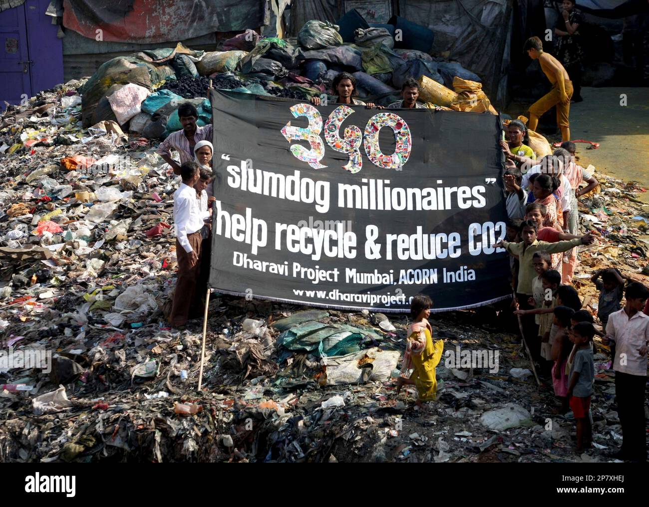 Residents of Dharavi, Asia's largest slum, hold a banner to mark the ...