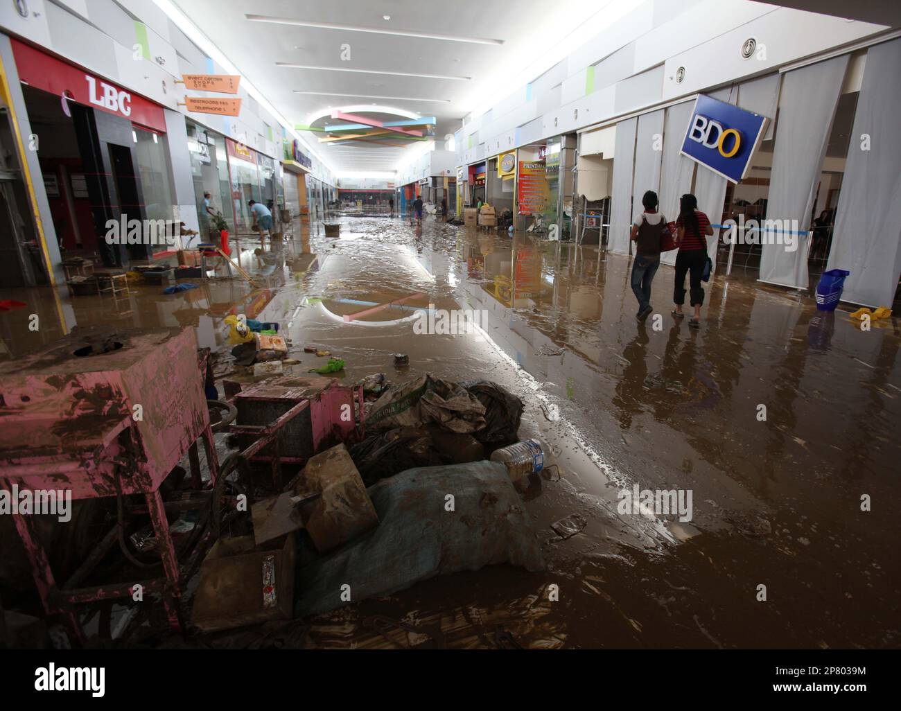 Employees prepare to clean up the mud inside a department store damaged ...