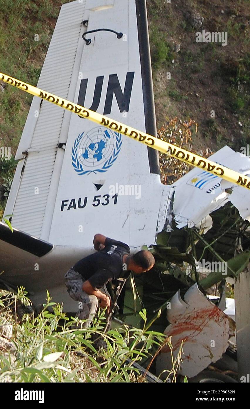 ** ALTERNATIVE CROP OF XRE107 ** A peacekeeper inspects the wreckage of ...