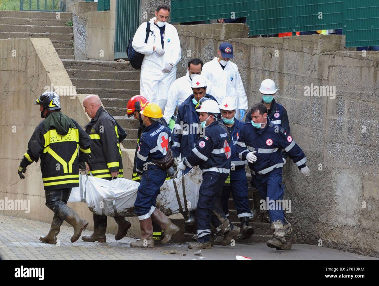 Rescue workers recover the victim of a mud slide that hit the town of ...