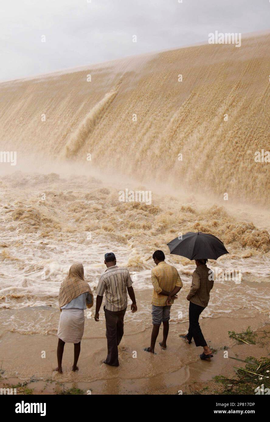 People look at an overflowing dam in Dindi, in Andhra Pradesh state ...