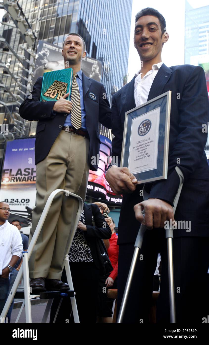 The world's tallest man, Sultan Kosen of Turkey, right, poses for pictures with a Guinness Book ...