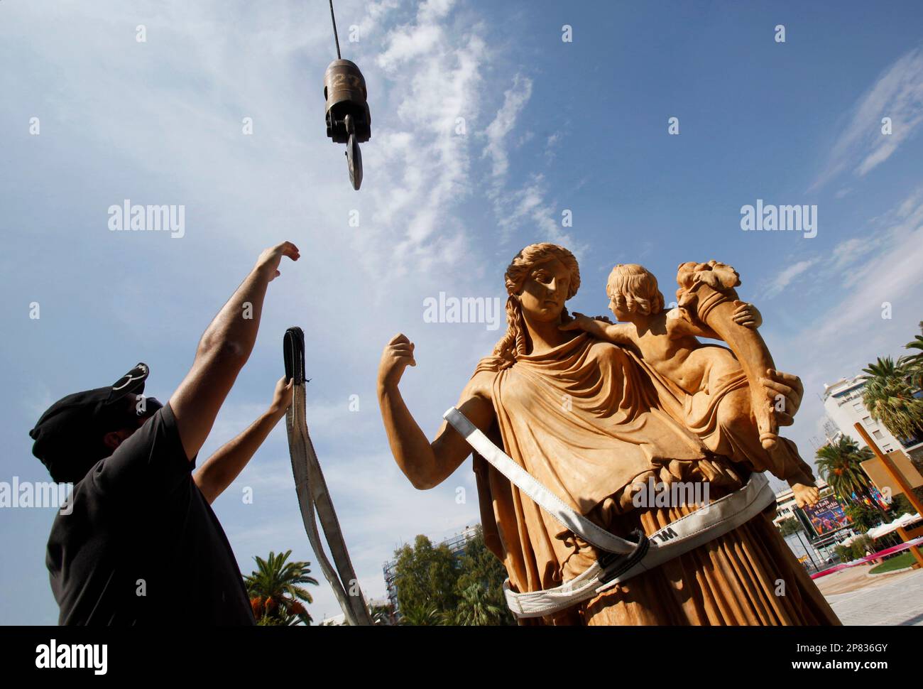 A worker prepares to hoist a replica of the ancient Greek statue of ...